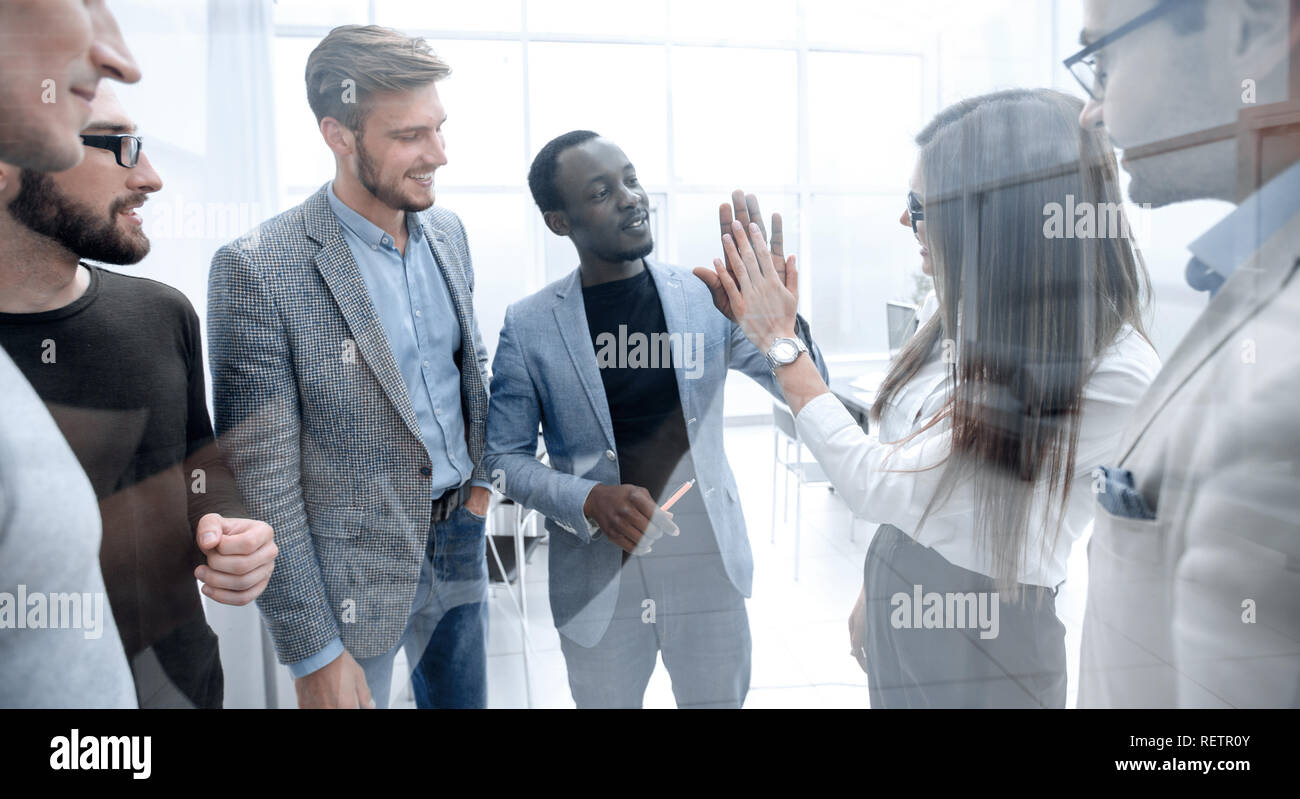Group of young colleagues giving each other a high five Stock Photo - Alamy