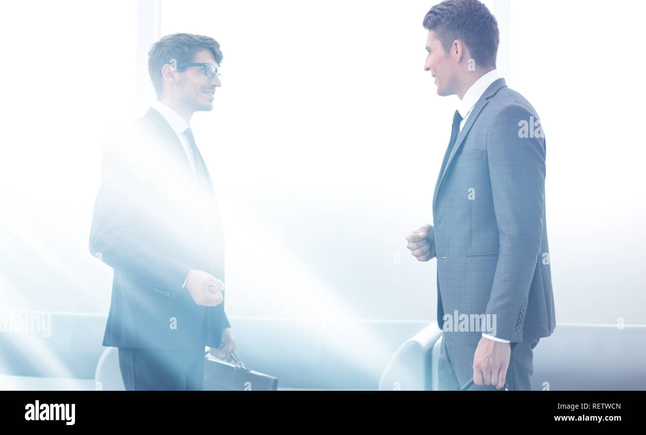 two business people talking standing in the office Stock Photo - Alamy
