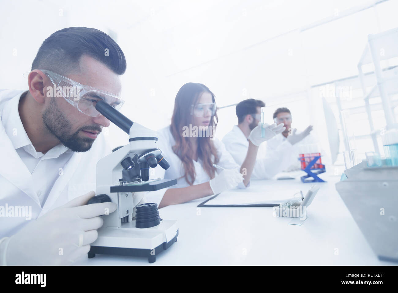 male laboratory technician looking at samples in the microscope Stock ...