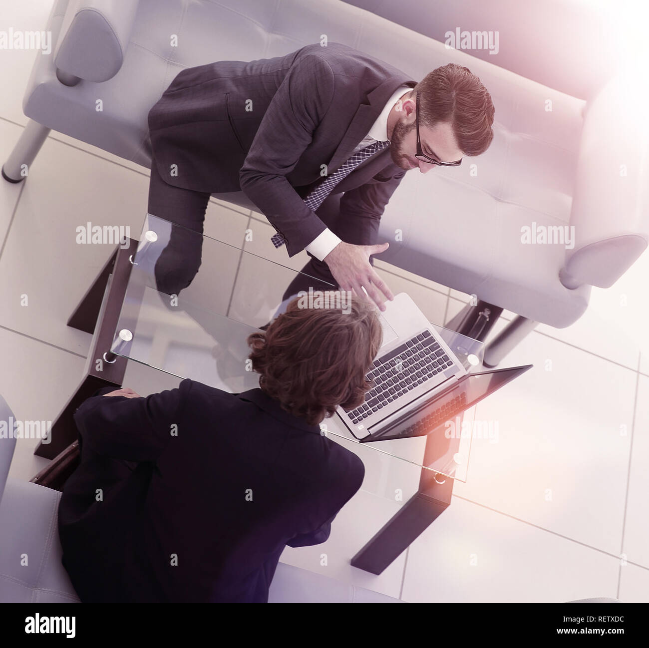 Two businessmen discussing tasks sitting at office table Stock Photo ...