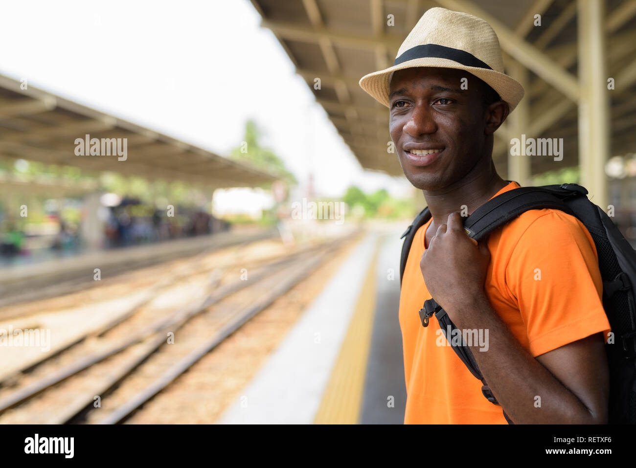 Face of African tourist man smiling and waiting train Stock Photo - Alamy