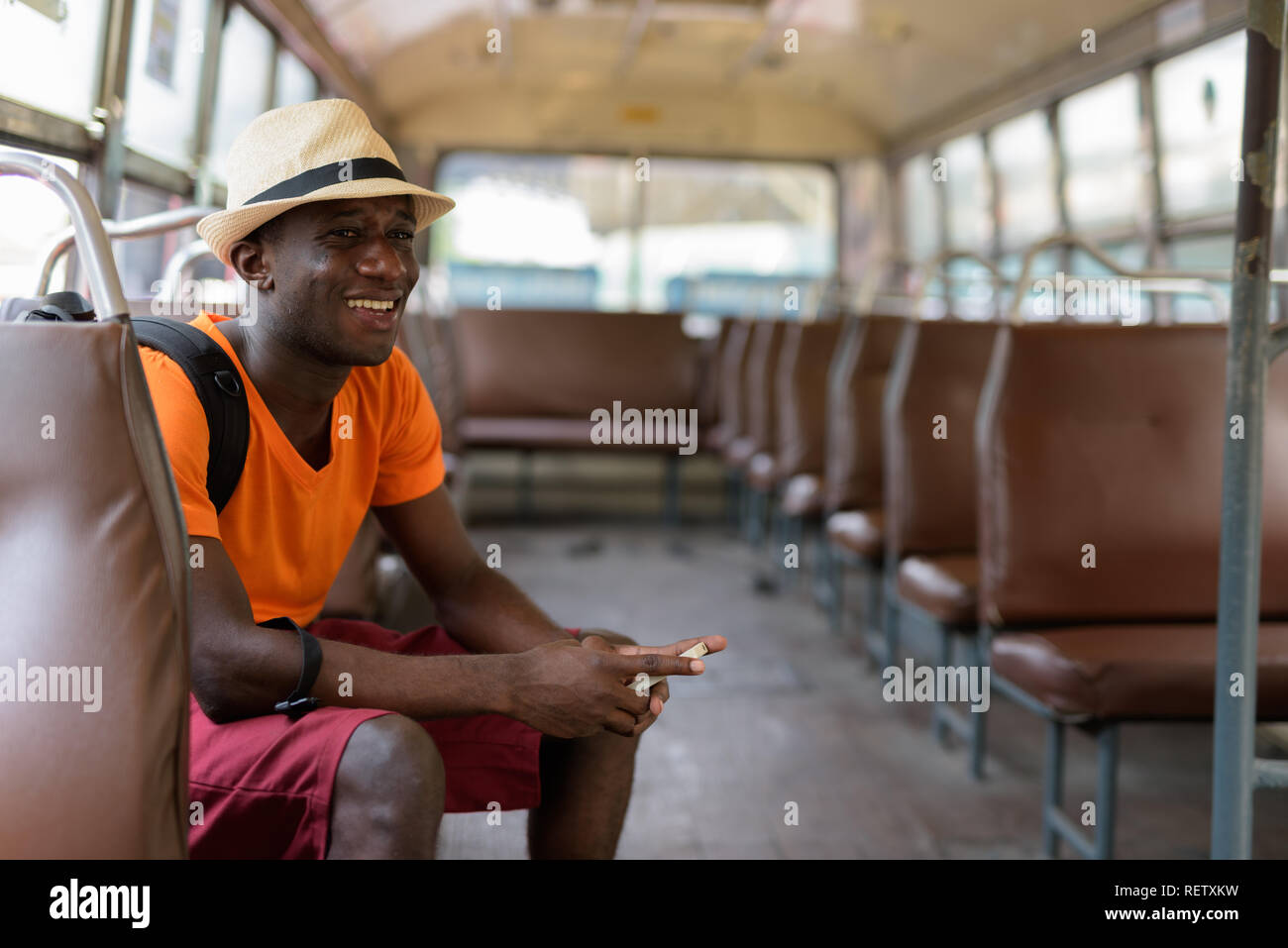 Thoughtful young happy black African tourist man smiling in bus Stock ...