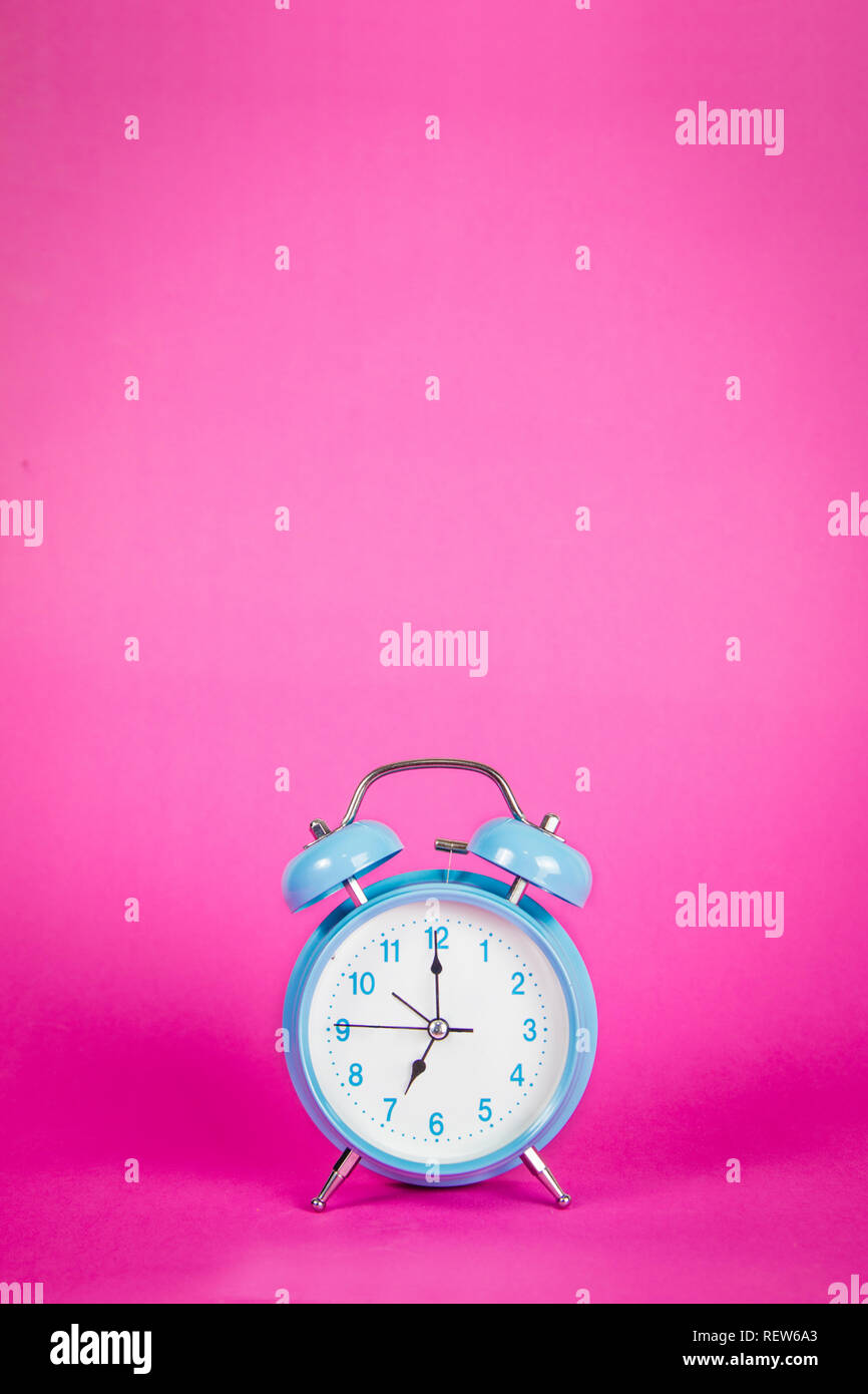 Beautiful retro blue pastel alarm clock on a vibrant pink background ...