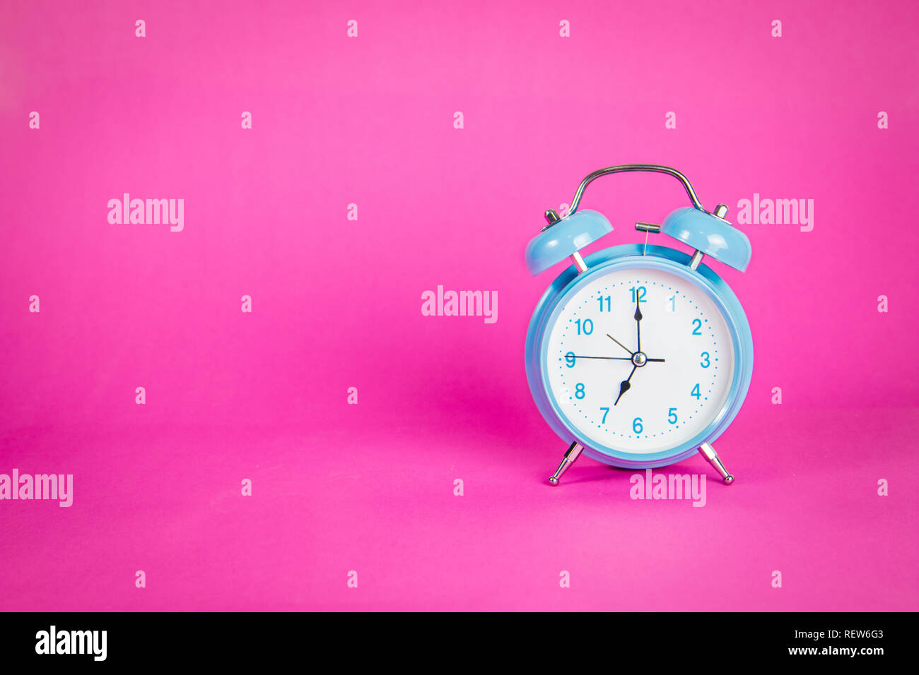 Beautiful retro blue pastel alarm clock on a vibrant pink background ...