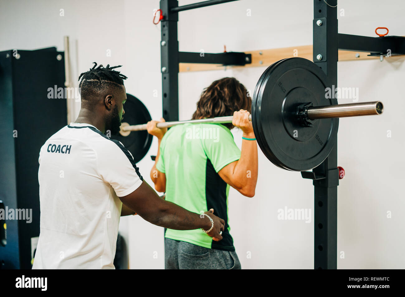 Black man coach training barbell with his patient in gym Stock Photo ...