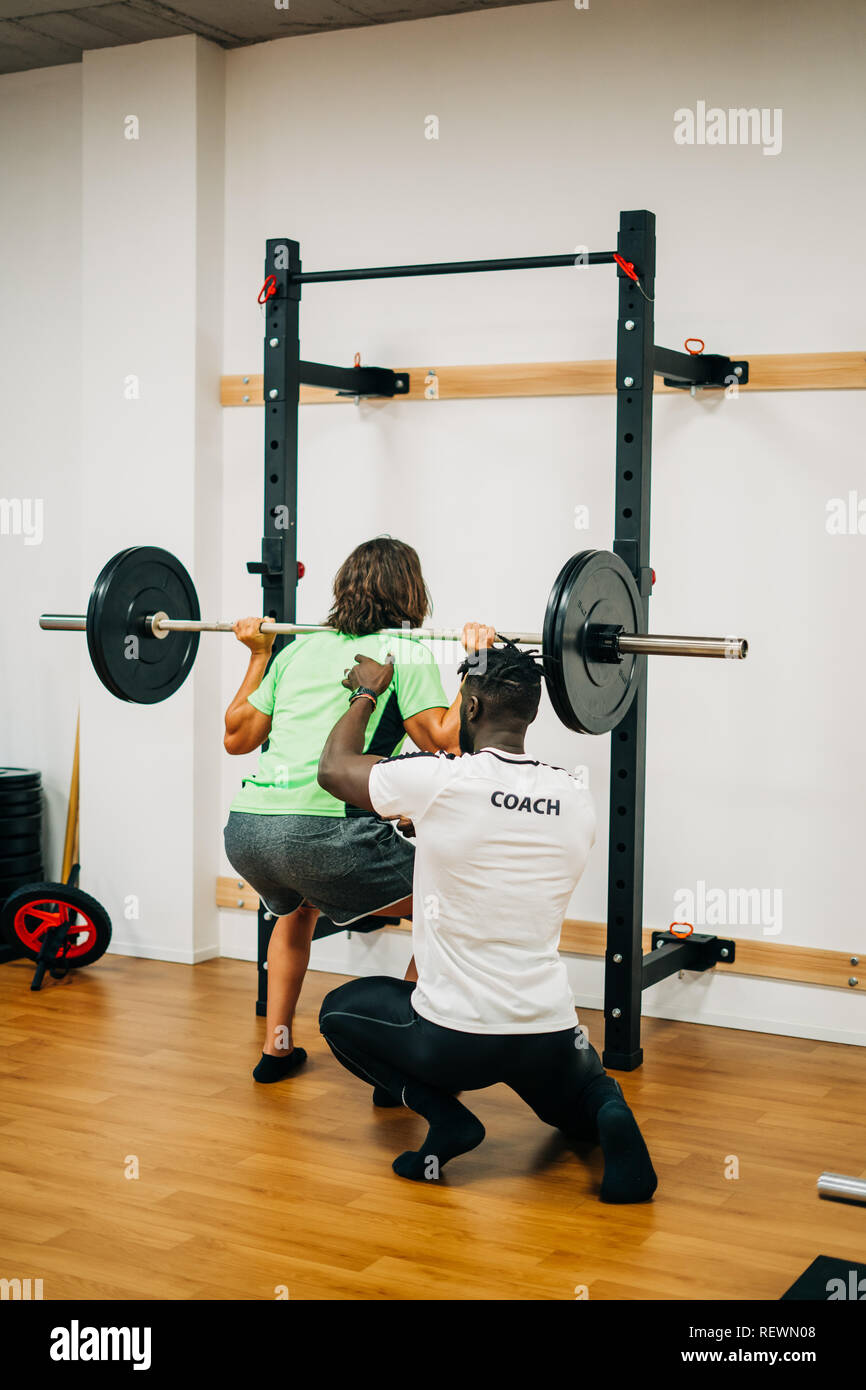 Black man coach training barbell with his patient in gym Stock Photo ...