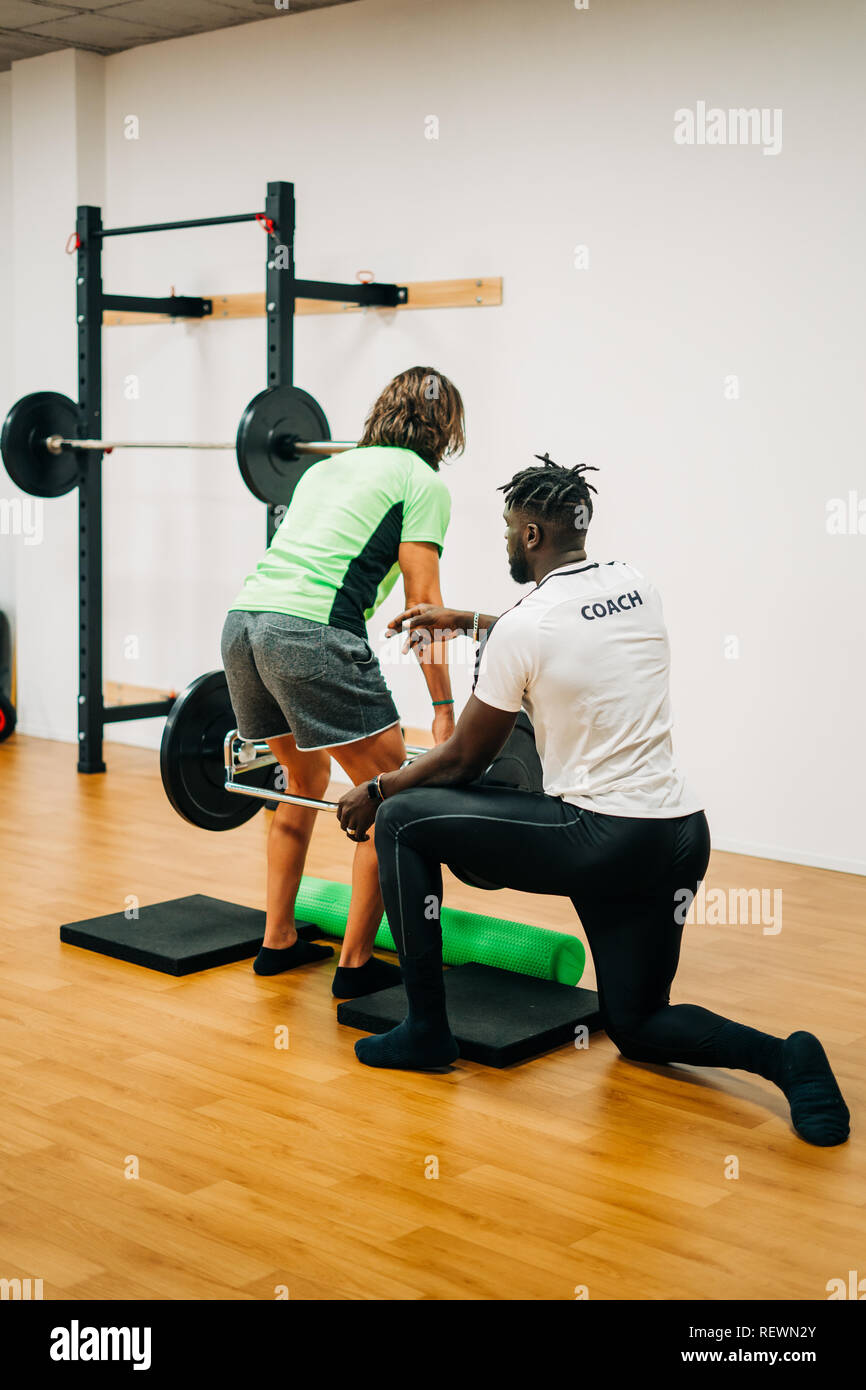 Black man coach training barbell with his patient in gym Stock Photo ...