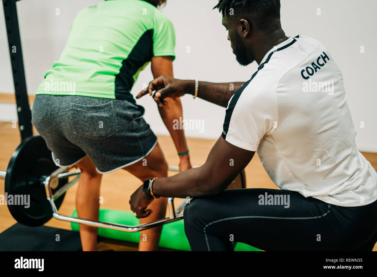 Black man coach training barbell with his patient in gym Stock Photo ...