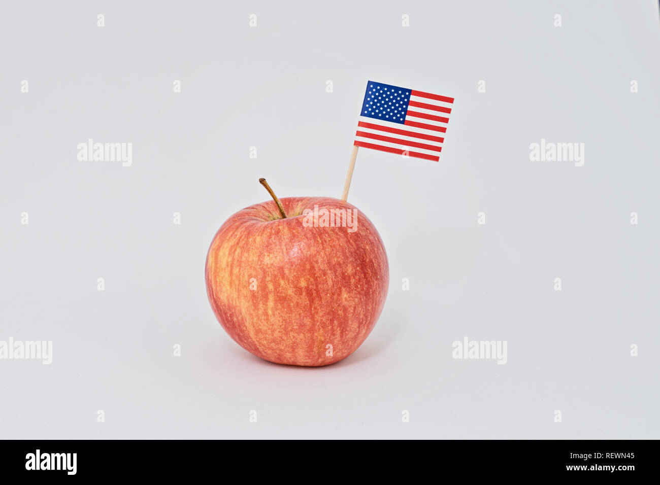 Ripe red apple and small American flag canape on white background ...