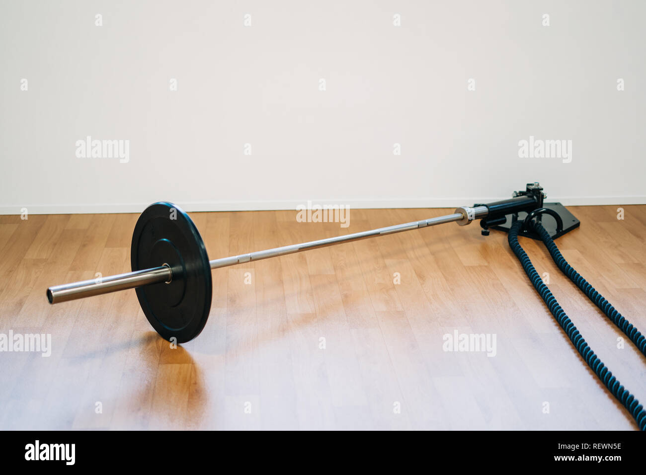 Training material, rope and barbell in gym Stock Photo - Alamy