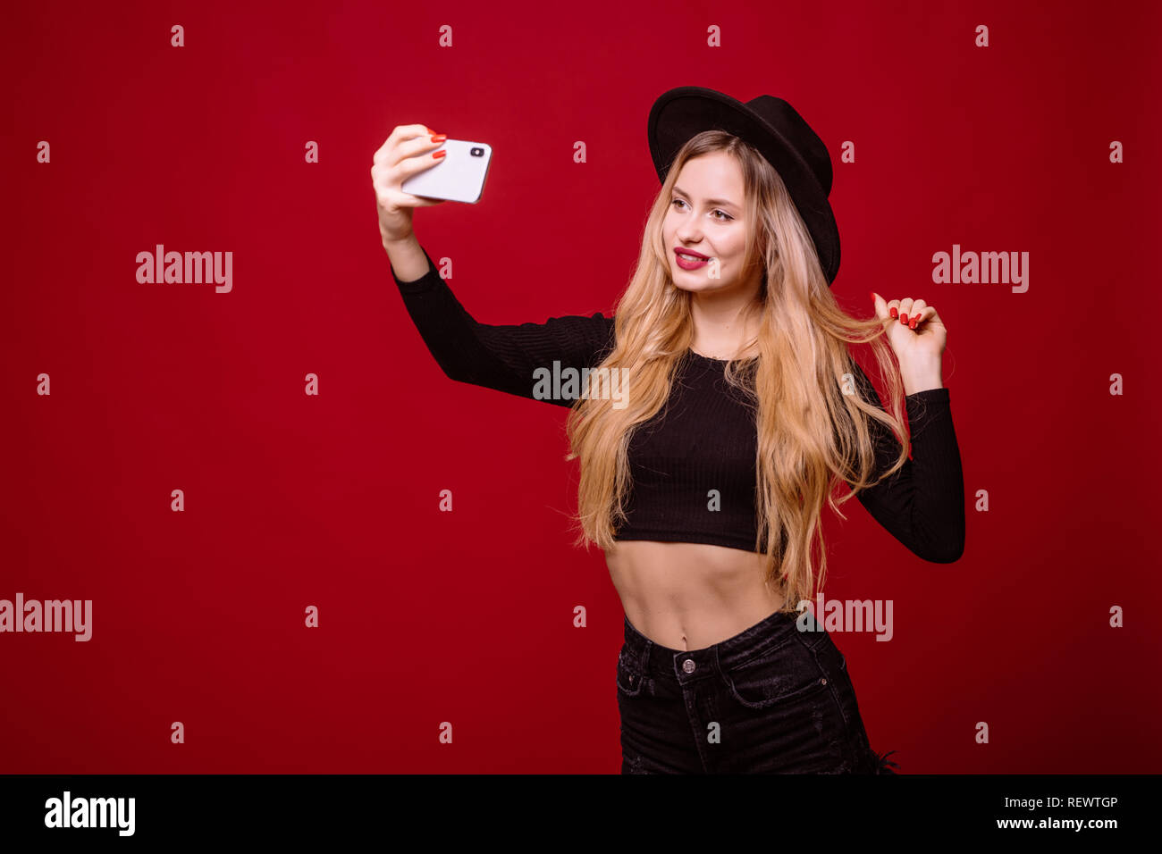 Cool classy woman in black t-shirt and hat taking selfie on her cell ...