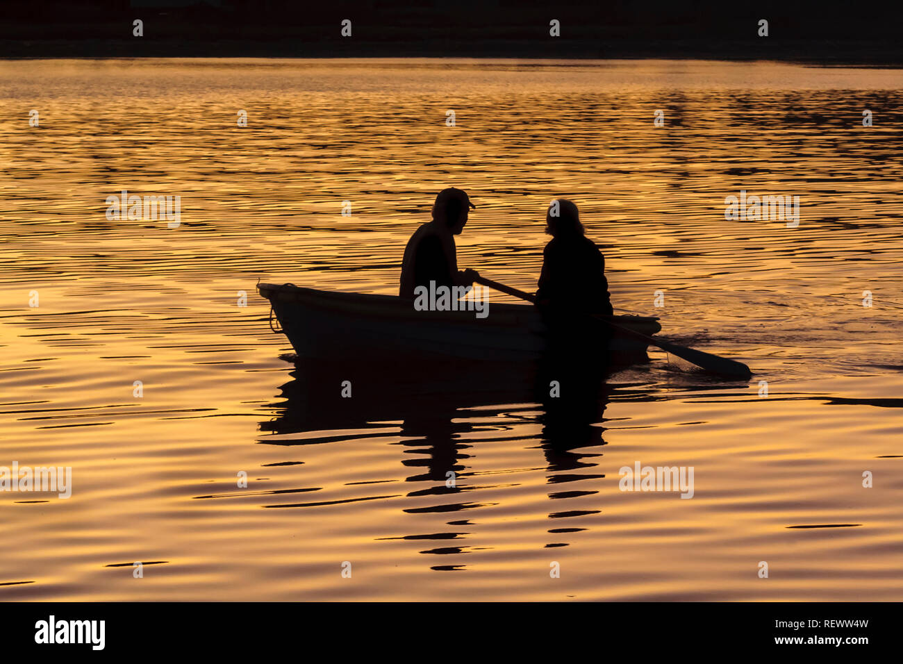 Woman rowing dinghy sunset hi-res stock photography and images - Alamy