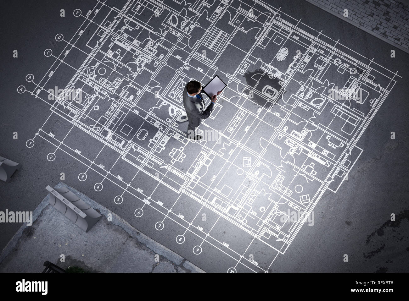 Top view of builder man and construction drawings on floor. Mixed media ...