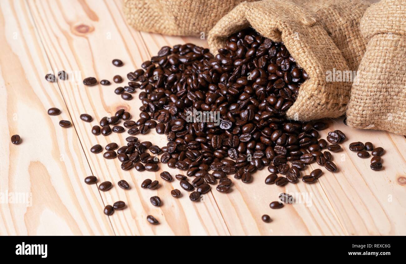 Coffee beans spilled out from burlap sack Stock Photo - Alamy