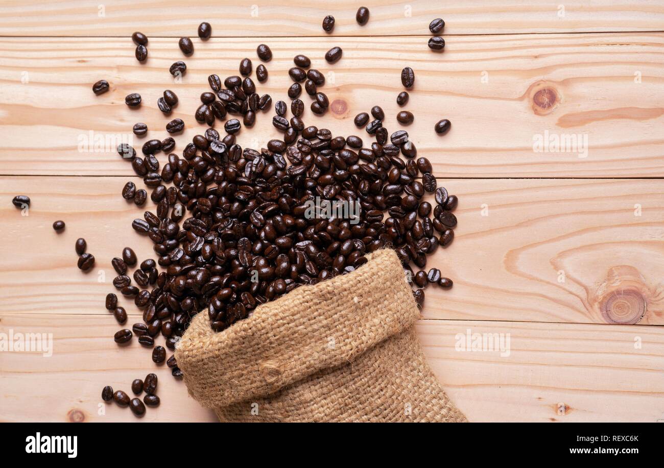 Coffee beans spilled out from burlap sack Stock Photo - Alamy