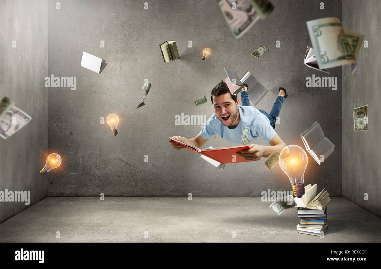 Funny guy with book in hands levitating in air. Mixed media Stock Photo ...