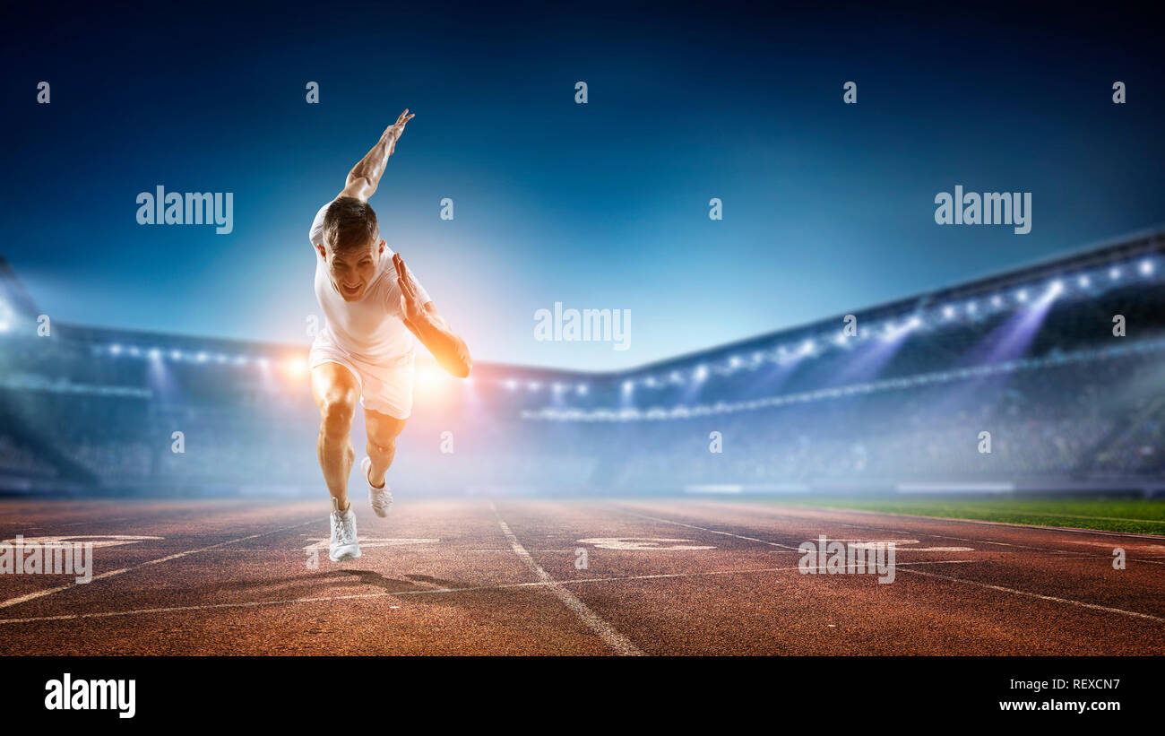 Athlete man running on racetrack at stadium mixed media hi-res stock ...