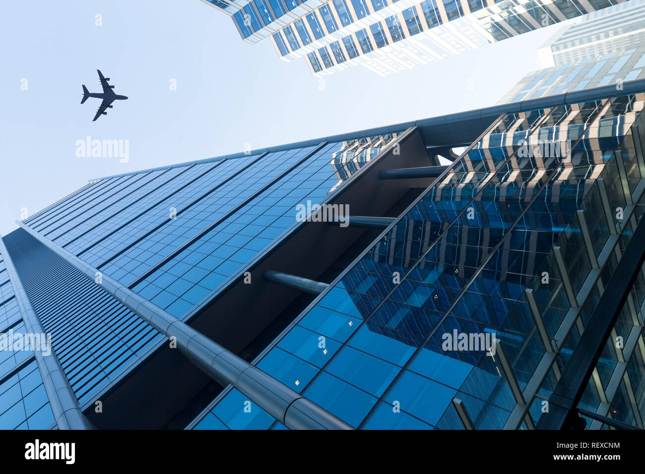Bottom angle view of airplane in sky over city buildings Stock Photo ...