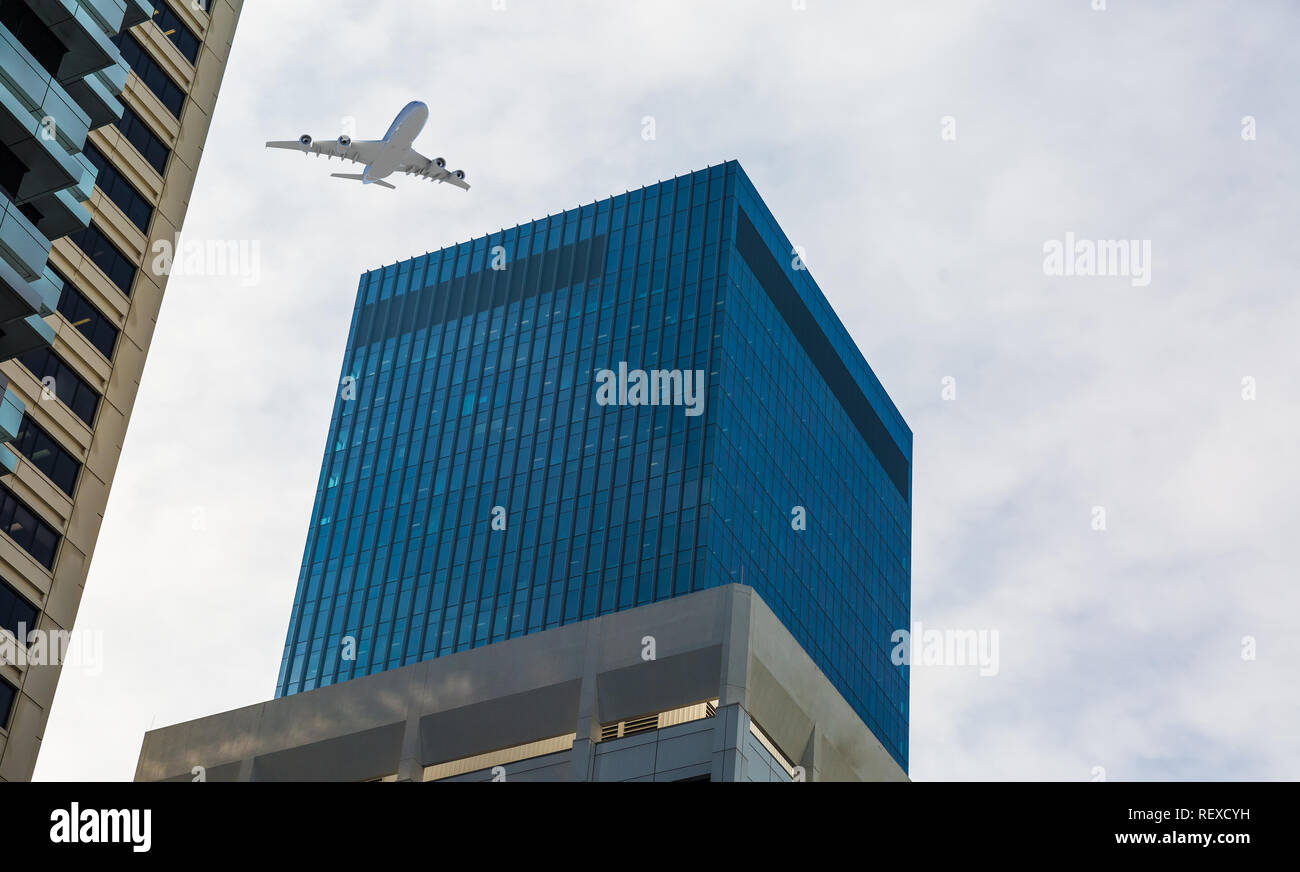 Bottom angle view of airplane in sky over city buildings Stock Photo ...