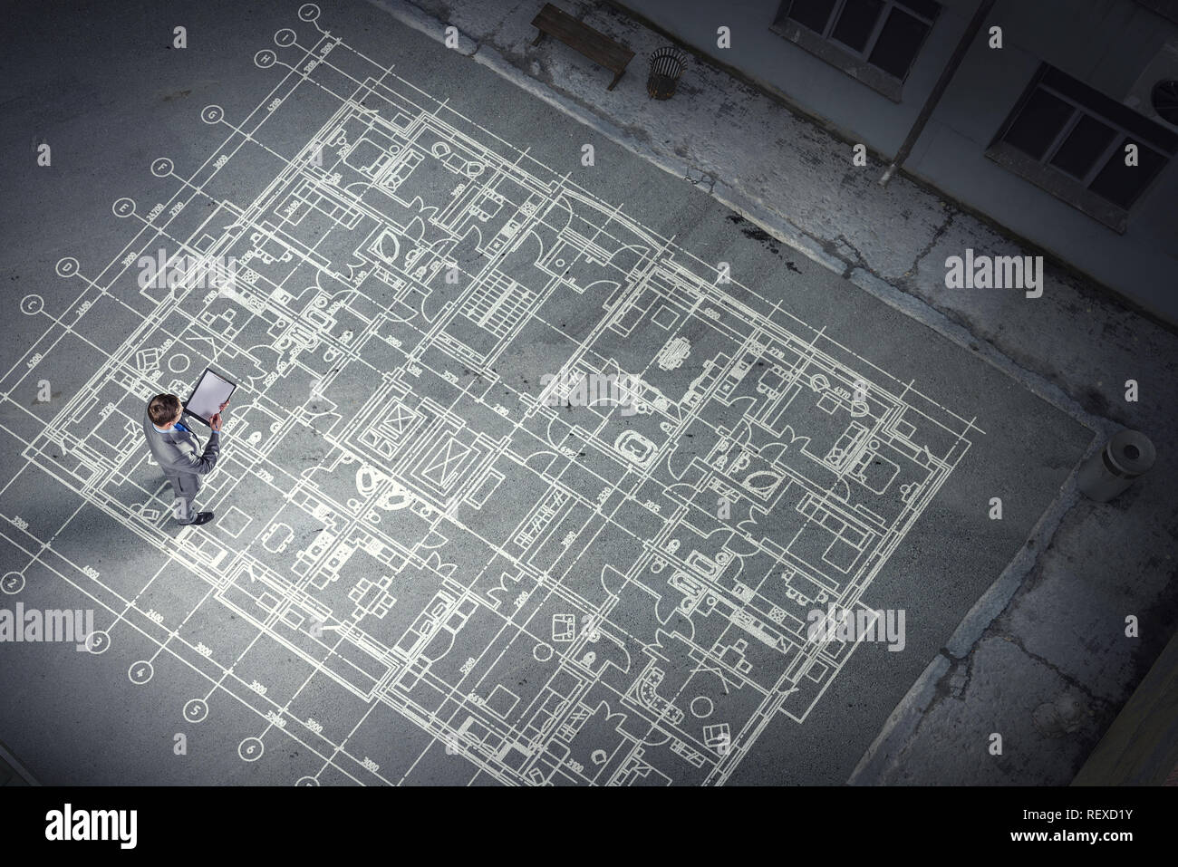 Top view of builder man and construction drawings on floor. Mixed media ...