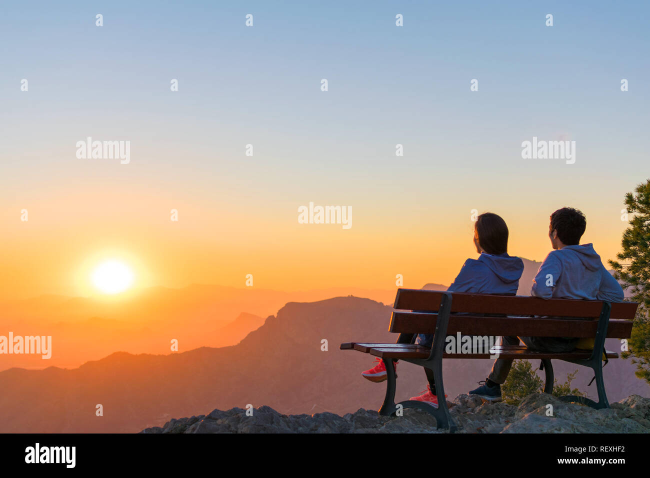 Romantic scene of couple watching sunrise Stock Photo - Alamy