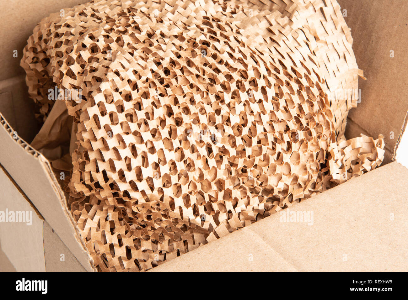 A bunched recyclable perforated brown paper filler on top of an opened ...