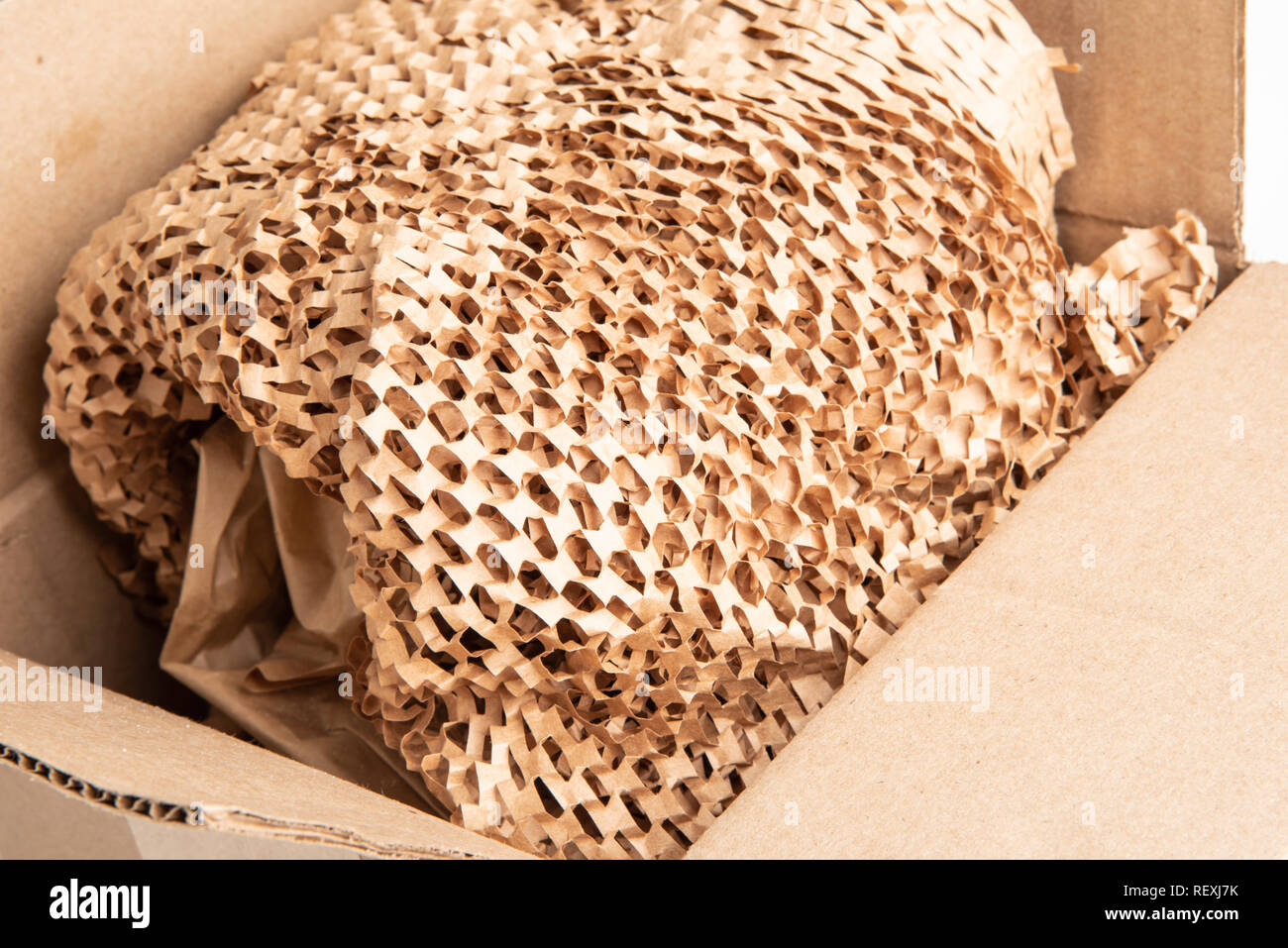 A bunched recyclable perforated brown paper filler on top of an opened ...