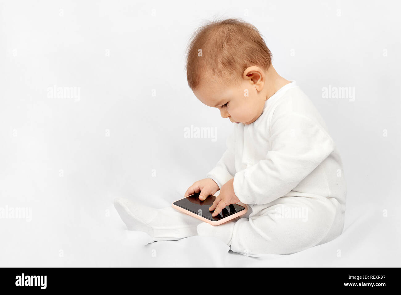 Baby holding a mobile phone isolated on white background generation z ...