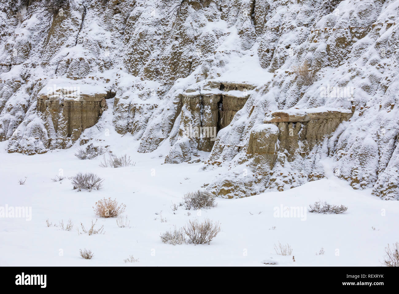 Erosional formations of sedimentary rocks and clay on a snowy November ...