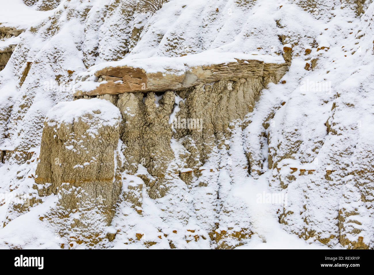 Erosional formations of sedimentary rocks and clay on a snowy November ...
