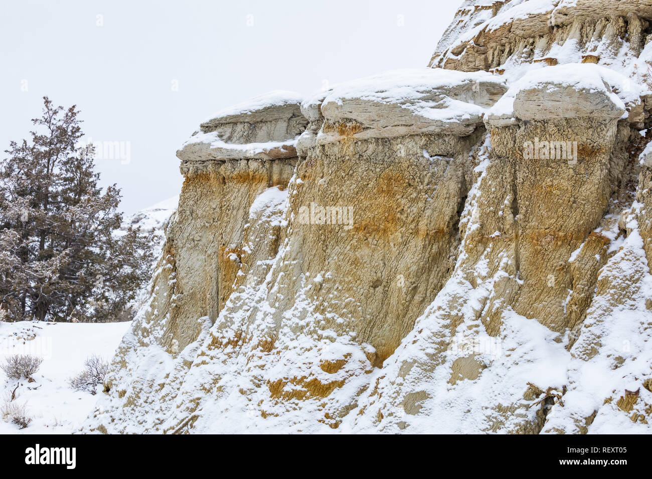 Erosional formations of sedimentary rocks and clay on a snowy November ...