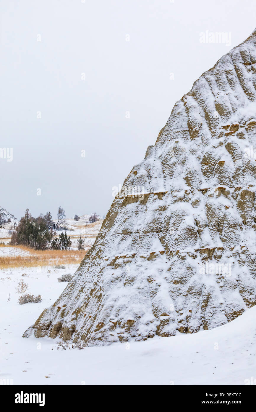 Erosional formations of sedimentary rocks and clay on a snowy November ...