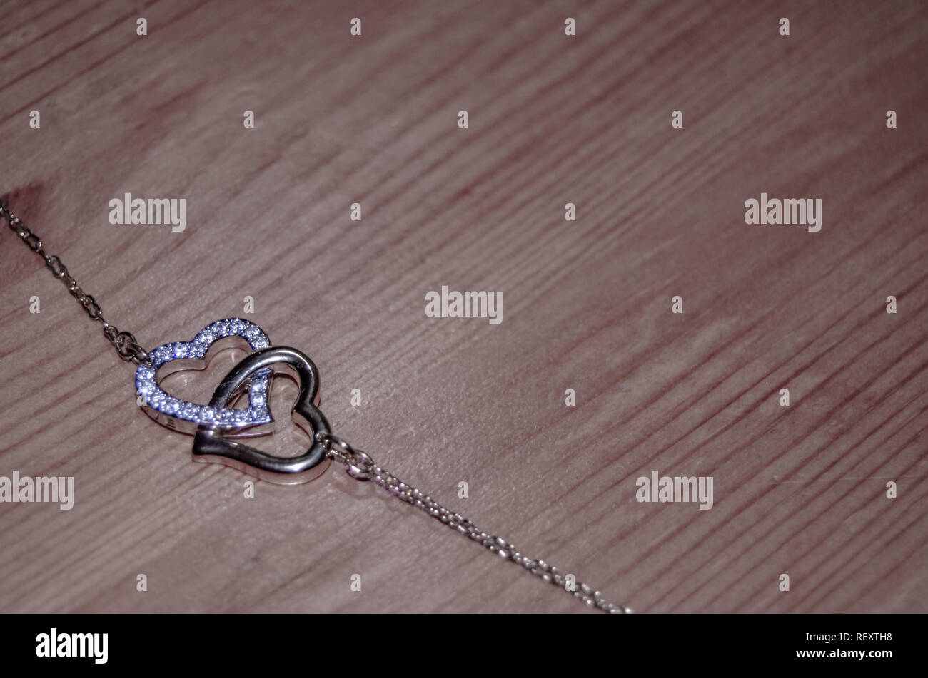 two heart bounded together handmade necklace on wooden table - love ...