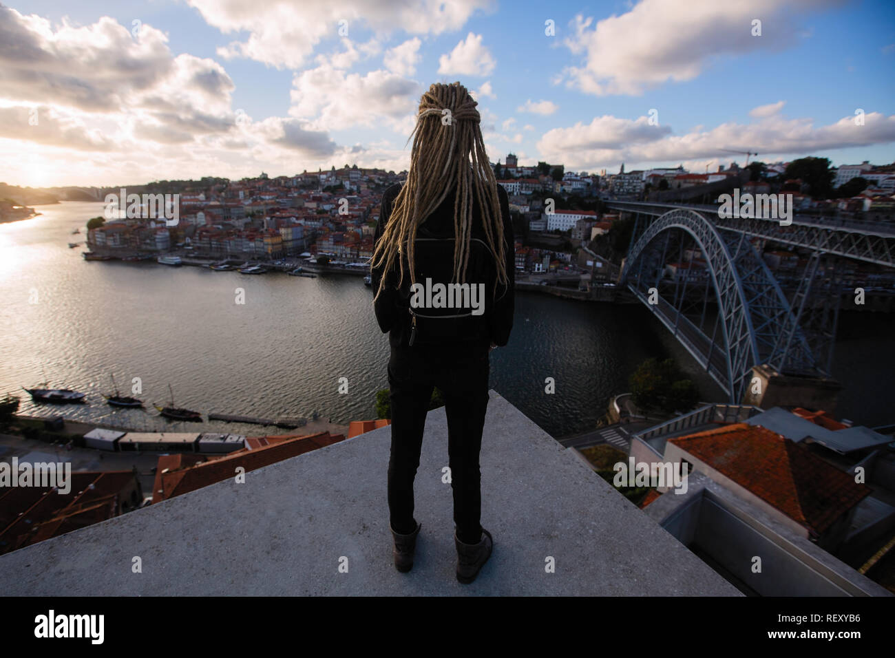 Young woman with blond dreadlocks standing on the viewing platform ...