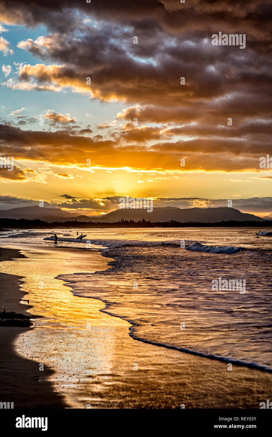 Sunset with surfers Stock Photo - Alamy