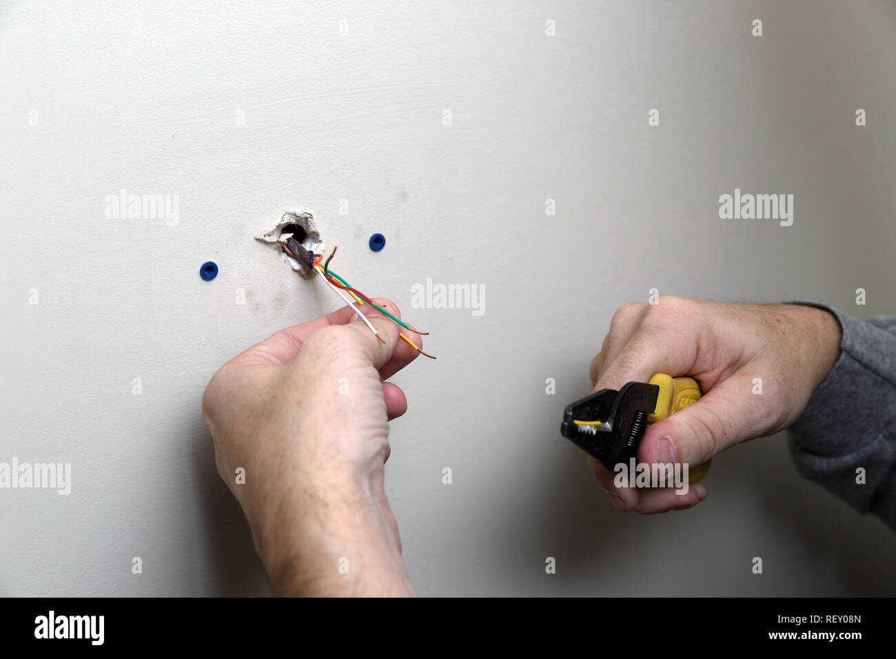 Close-up of hand holding Control wire for thermostat used with a HVAC ...