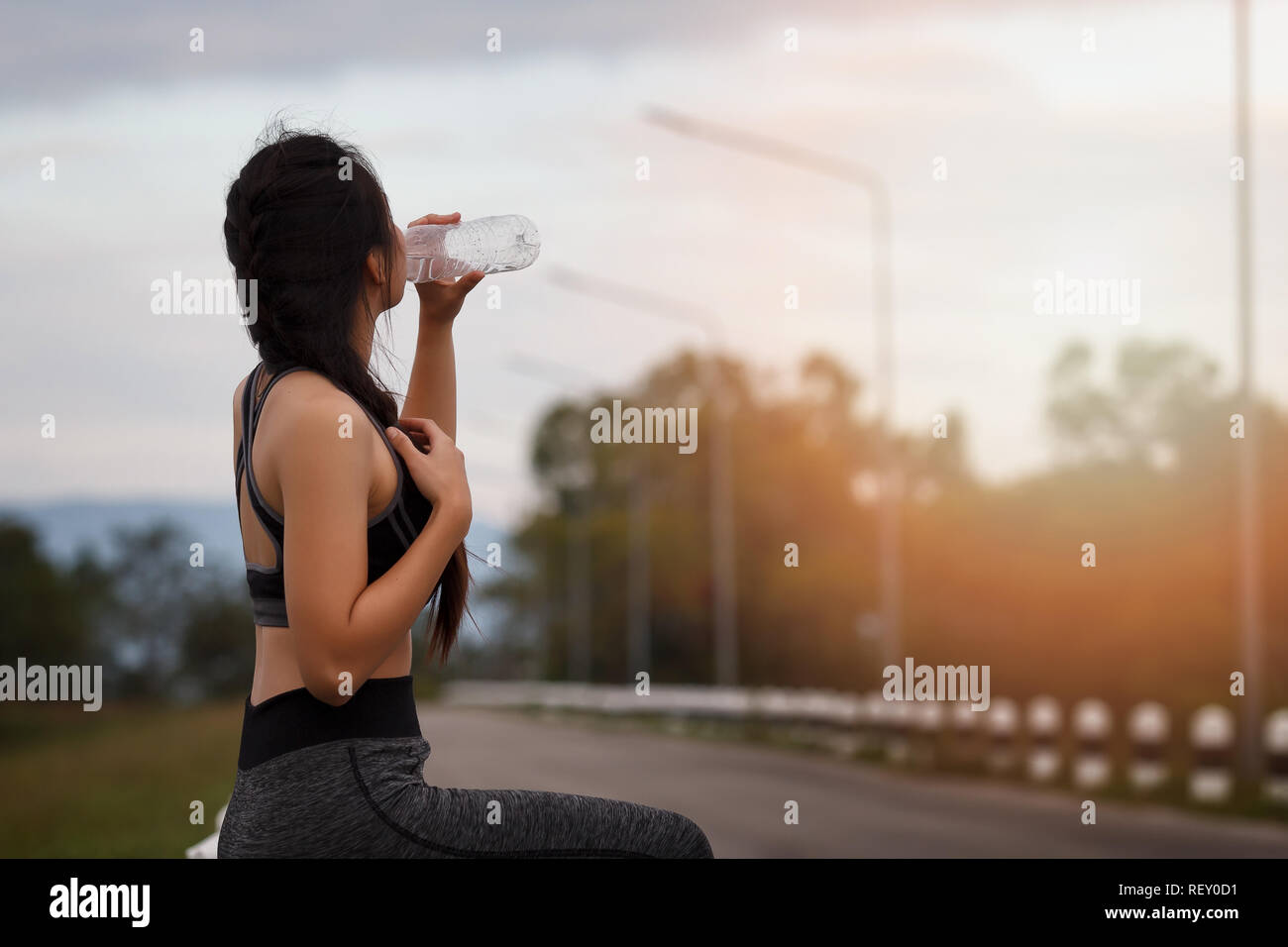 Attractive healthy fitness girl drinking water after workout. Runner ...