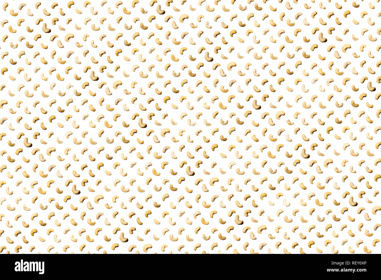 A collection of cashew lie in straight rows along dioganals on an ...