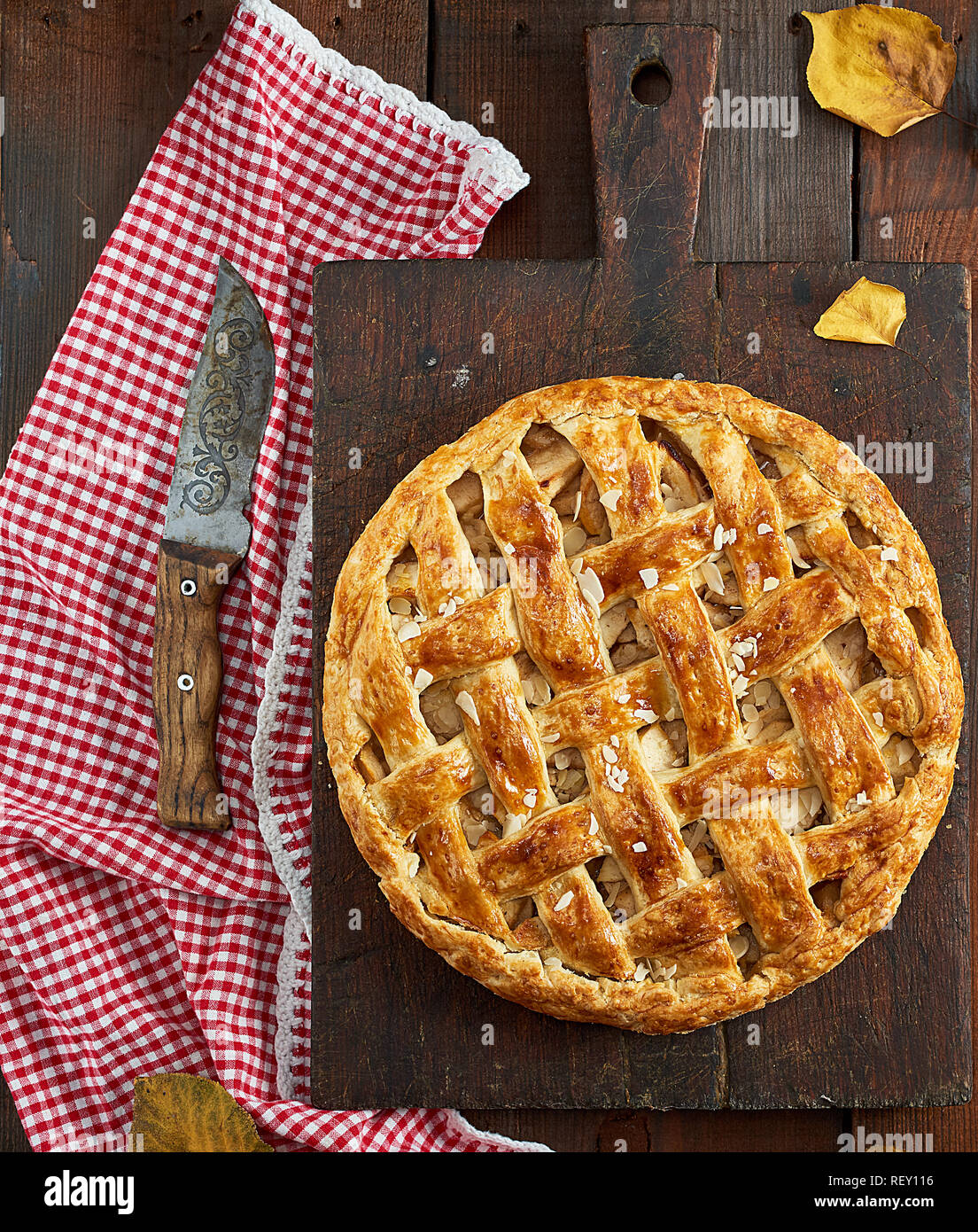 Baked whole round apple pie on a rectangular old brown board, wooden ...