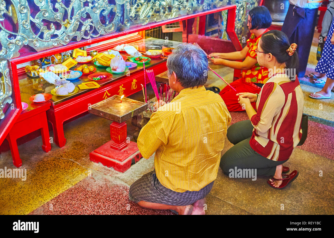 YANGON, MYANMAR - FEBRUARY 17, 2018: The family prayer with incense ...