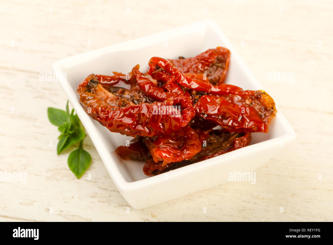 Dried tomato in olive oil with basil leaves Stock Photo - Alamy