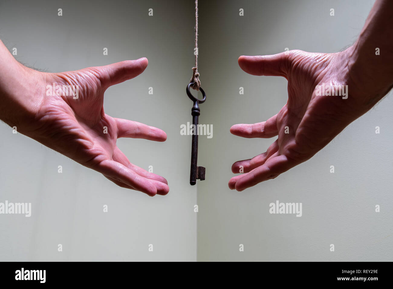People hands reaching for vintage key hanging on a string. Business ...