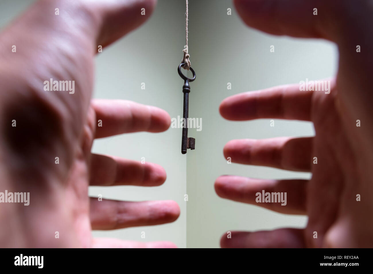 People hands reaching for vintage key hanging on a string. Business ...