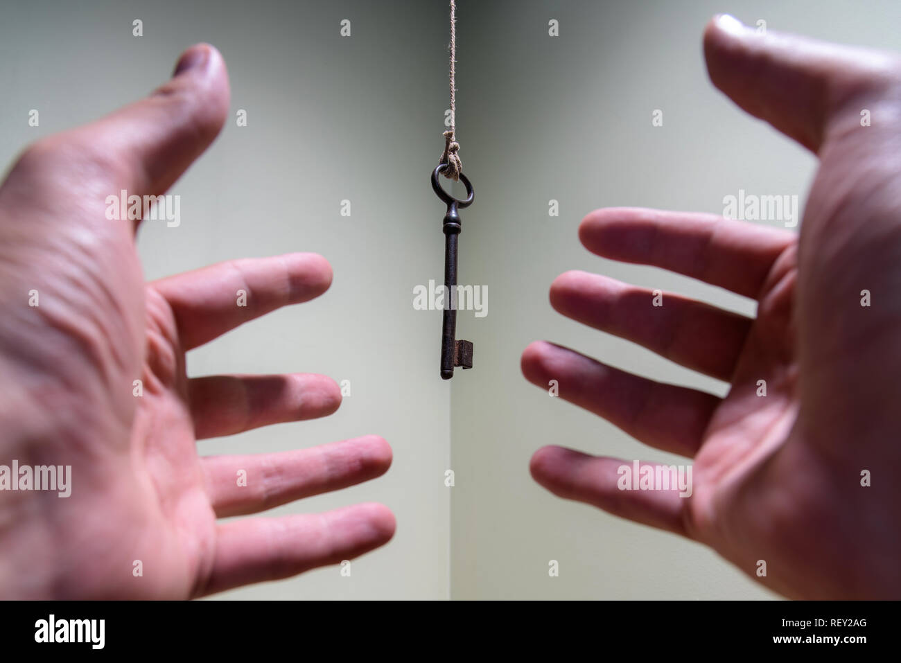 People hands reaching for vintage key hanging on a string. Business ...