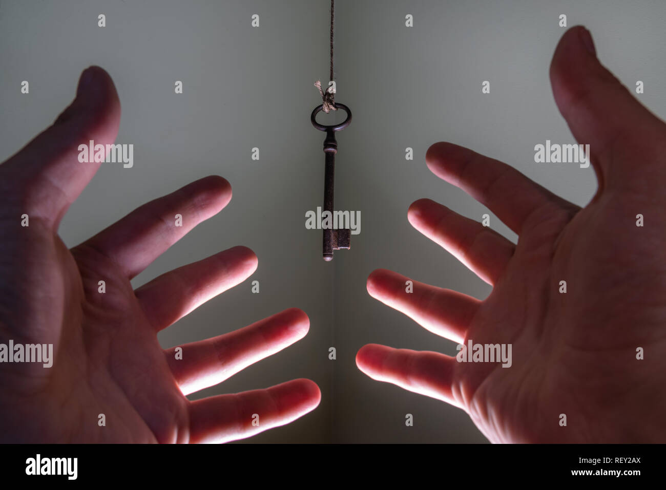 People hands reaching for vintage key hanging on a string. Business ...