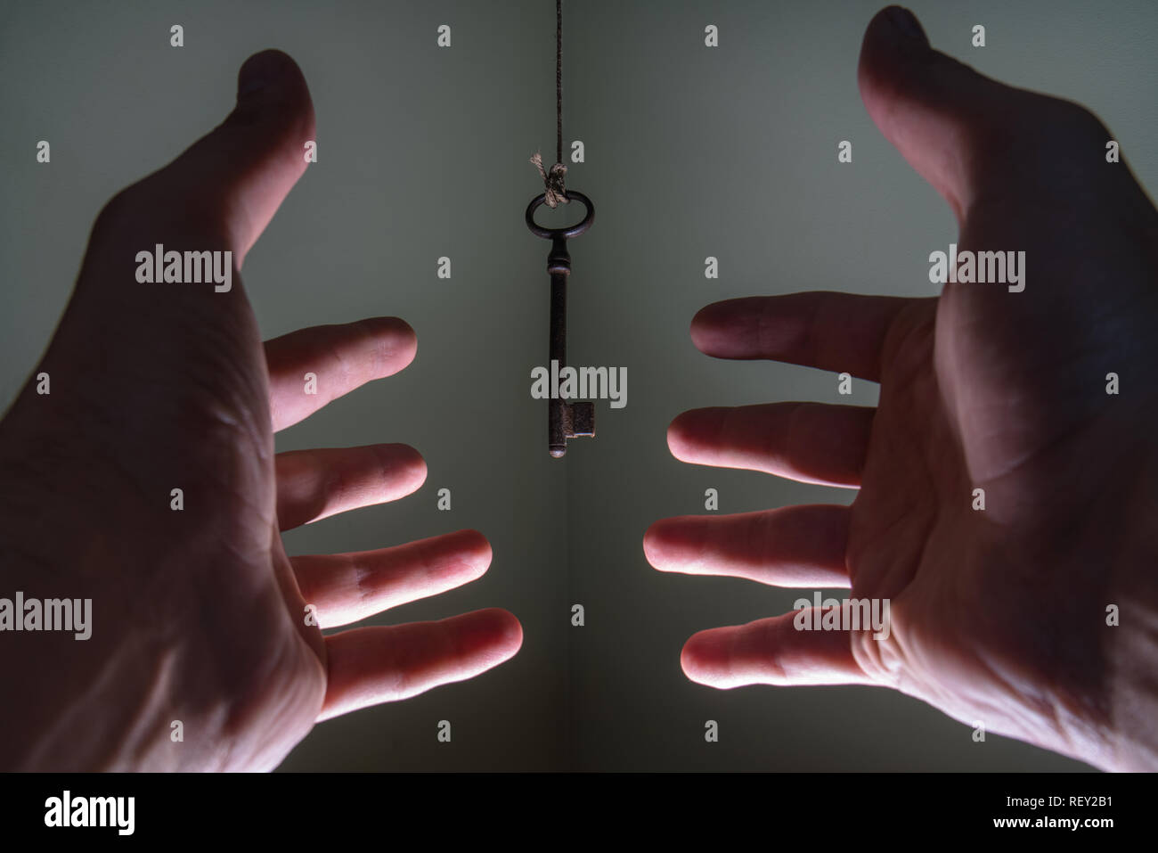 People hands reaching for vintage key hanging on a string. Business ...