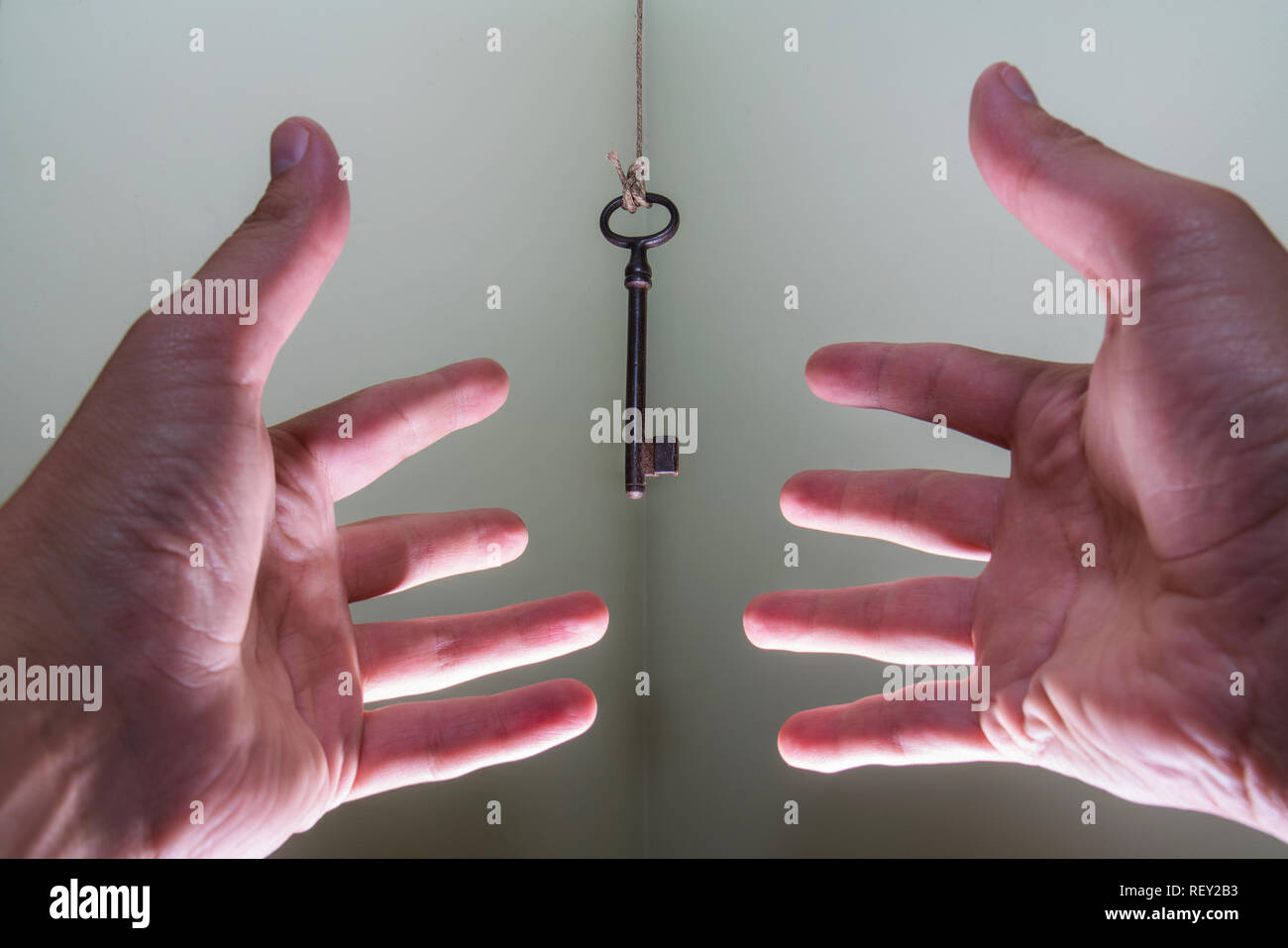 People hands reaching for vintage key hanging on a string. Business ...
