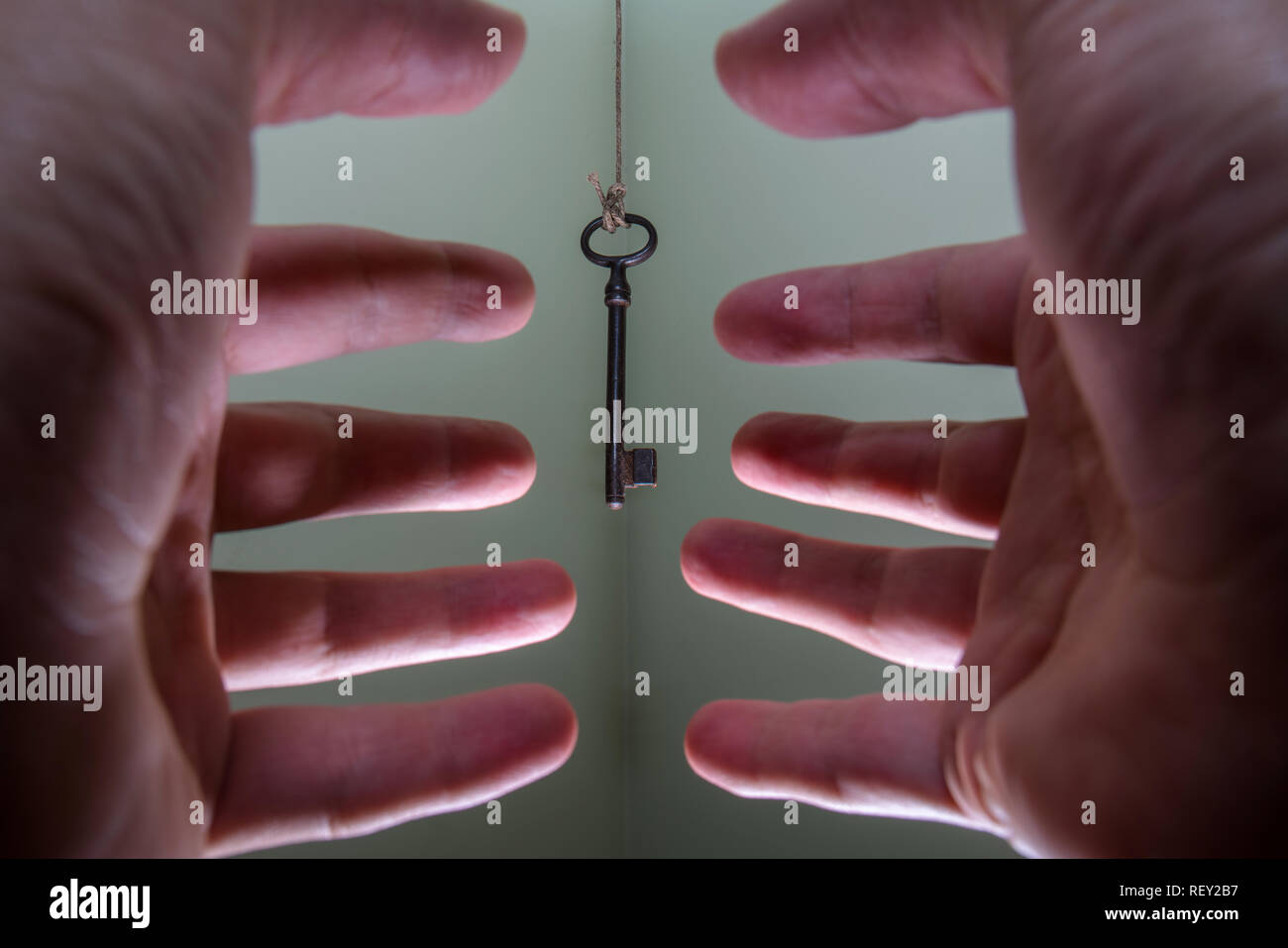 People hands reaching for vintage key hanging on a string. Business ...