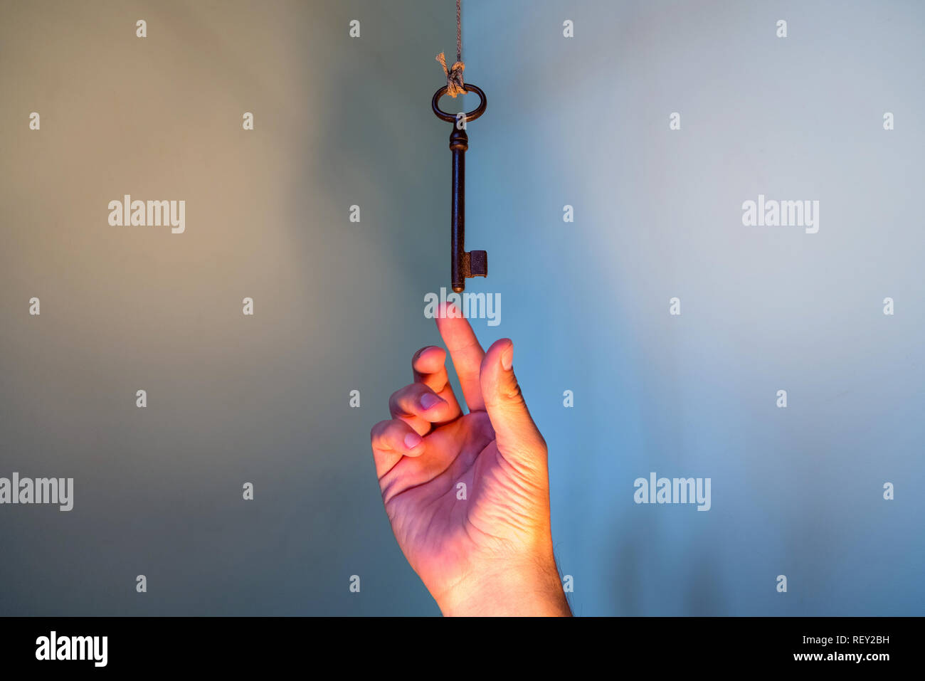 People hand reaching for vintage key hanging on a string. Business ...