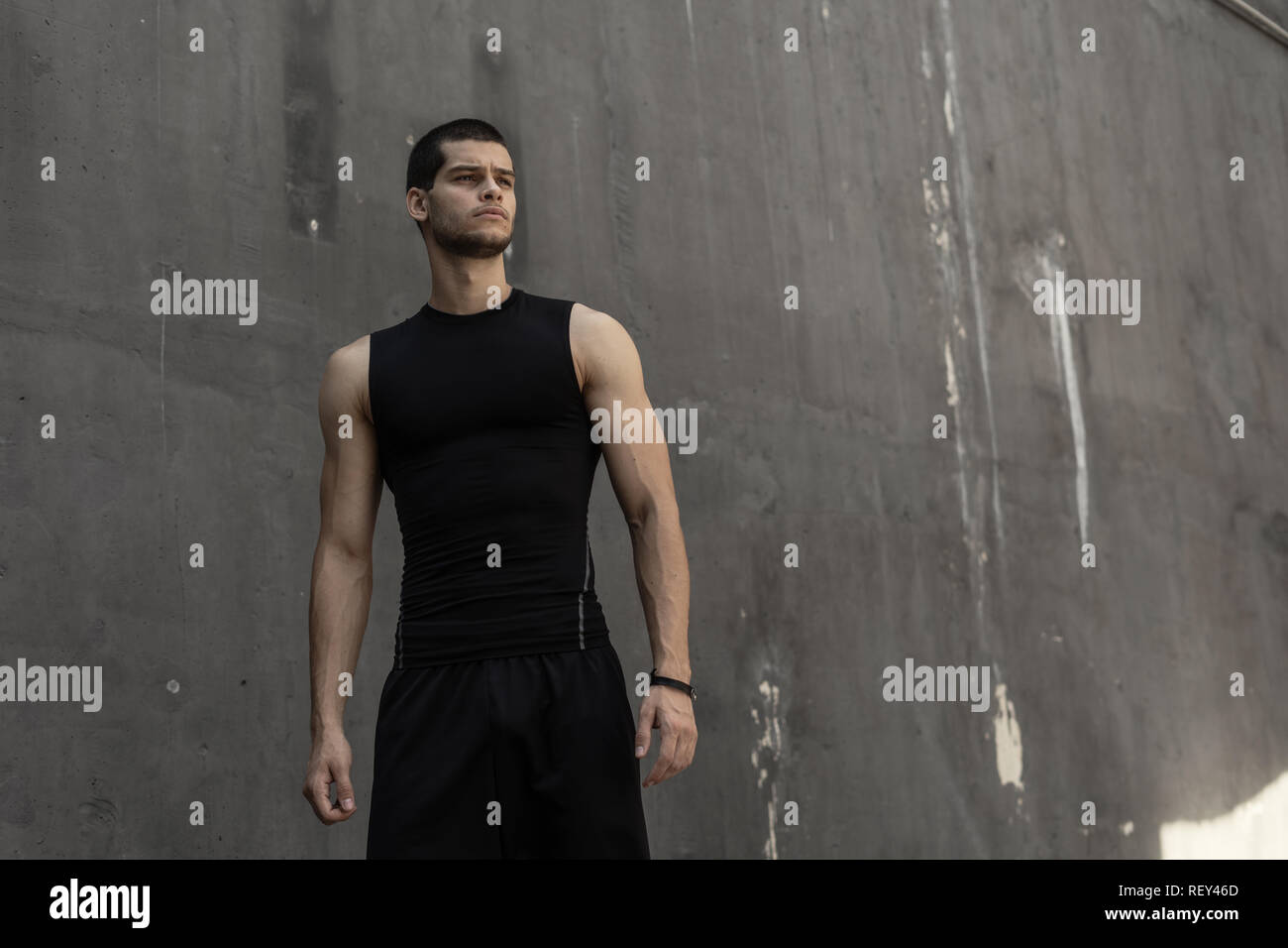Portrait of athletic muscular young man, in sports clothing, posing on ...